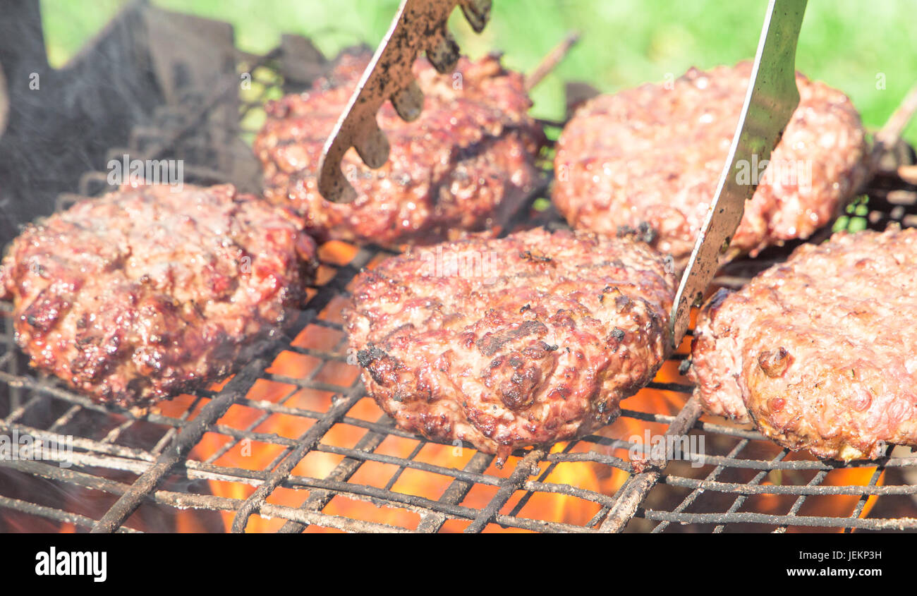 Top view of burger chops preparing on grill on countryside backgrond ...