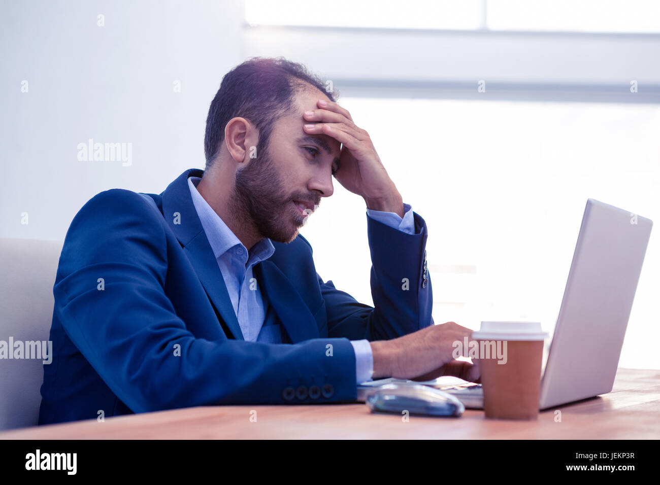 Bored man working on laptop in office Stock Photo - Alamy
