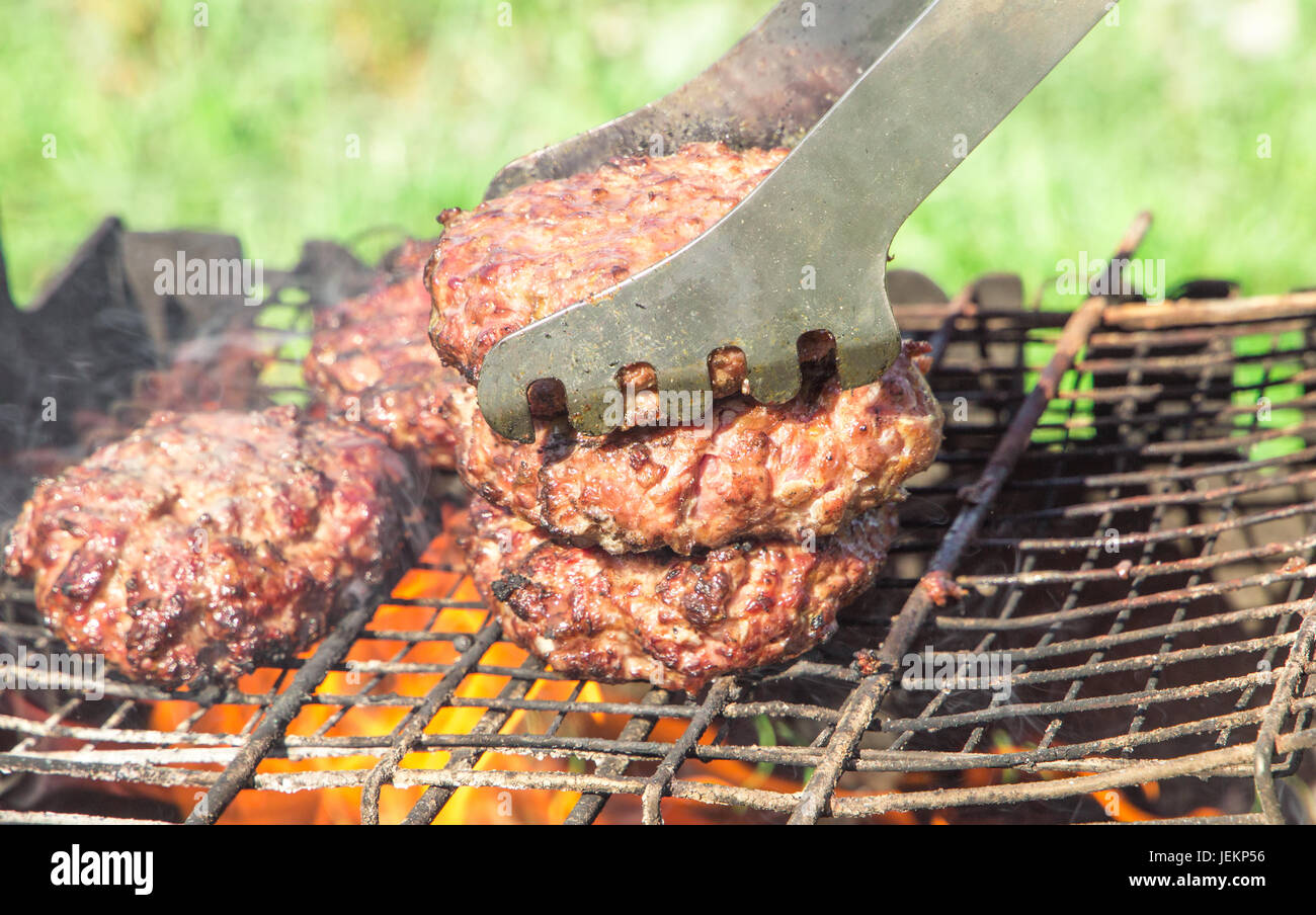 Top view of burger chops preparing on grill on countryside backgrond ...