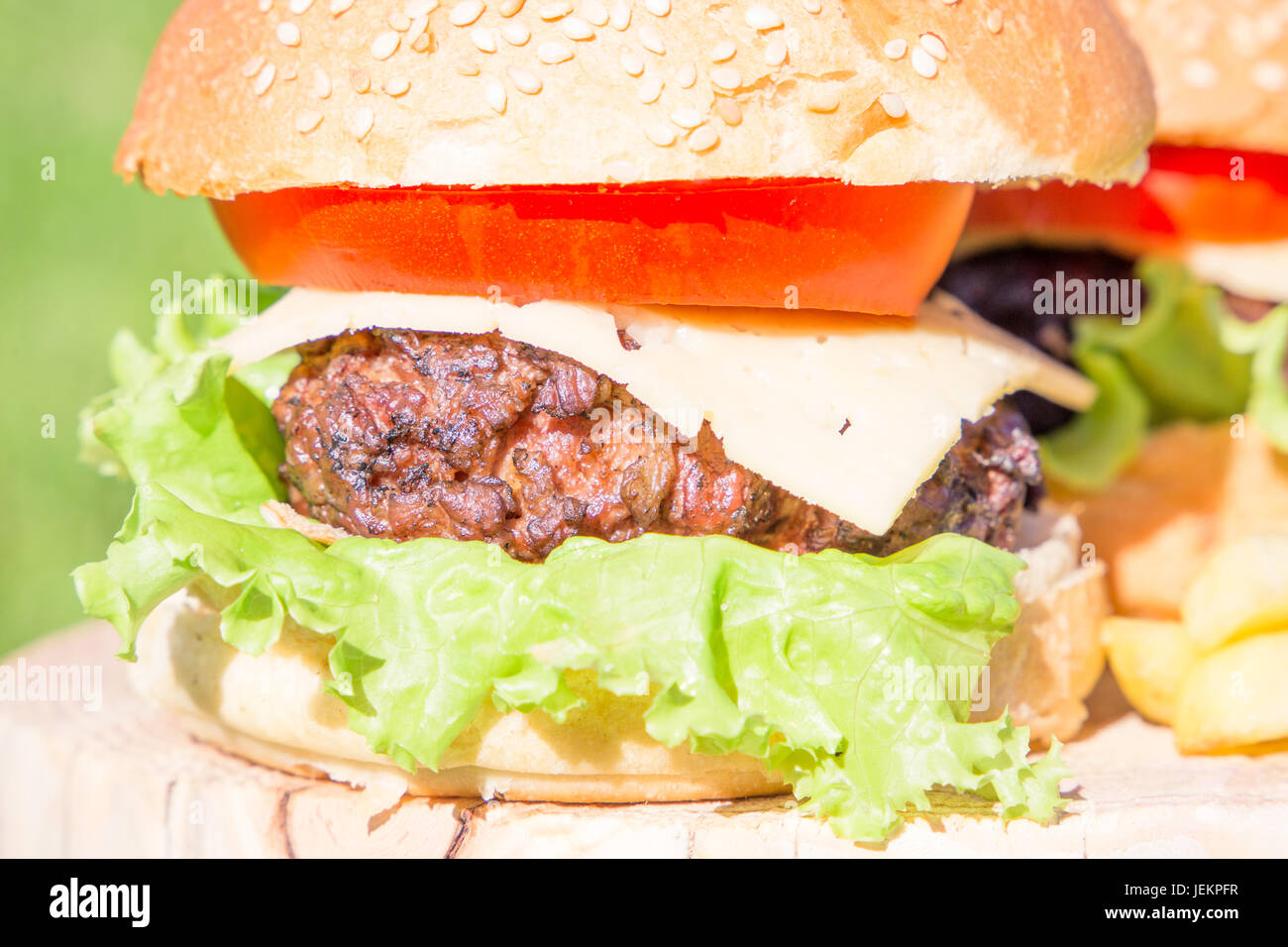 Beef burger with cheese and vegetables with garnish on grass Stock ...