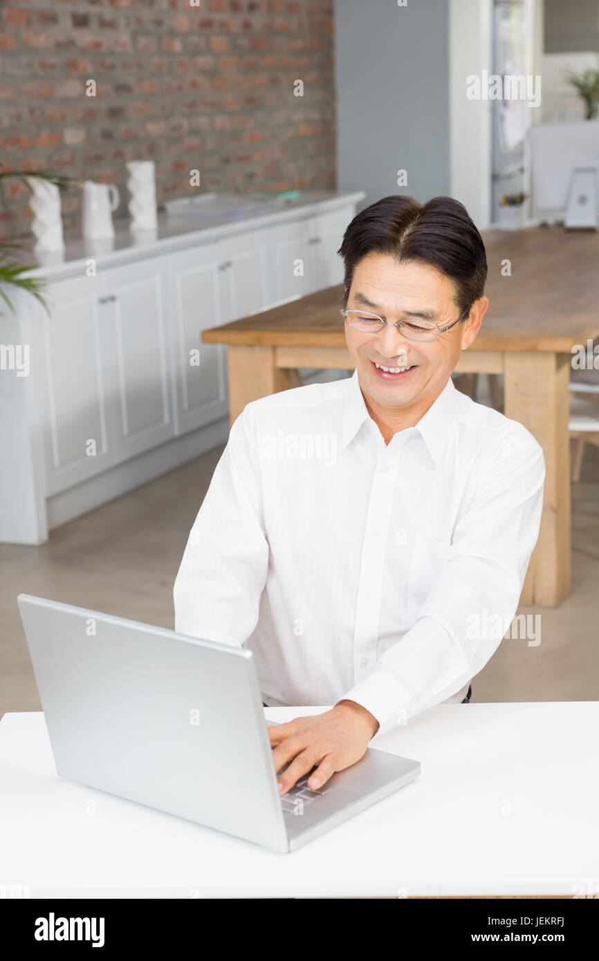 Smiling man using laptop Stock Photo - Alamy