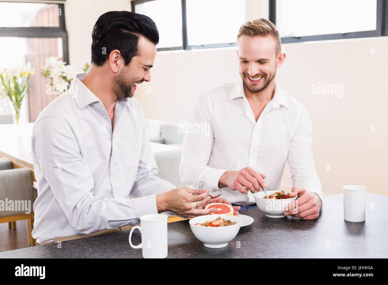 Smiling gay couple having breakfast Stock Photo - Alamy