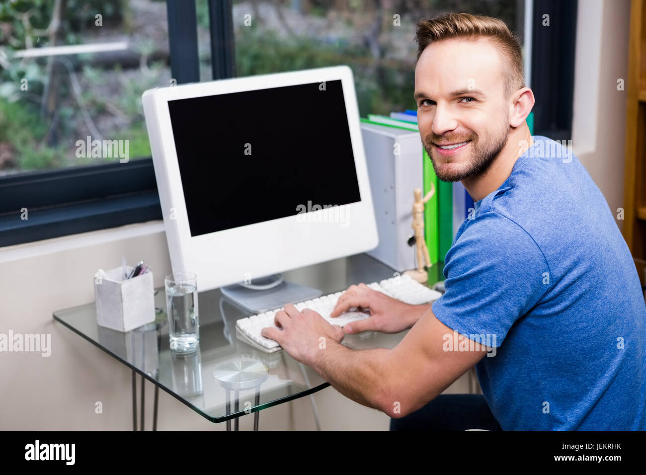 Smiling handsome man using computer Stock Photo - Alamy