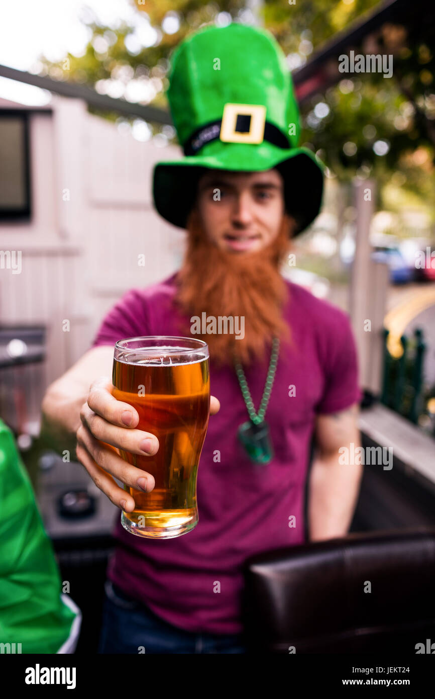 Disguised man holding a pint Stock Photo - Alamy