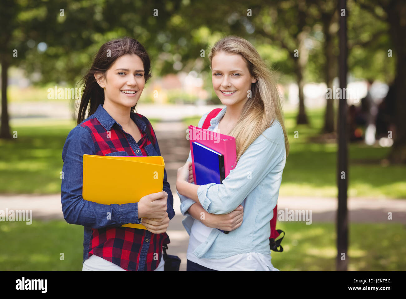 Smiling students holding binder Stock Photo - Alamy