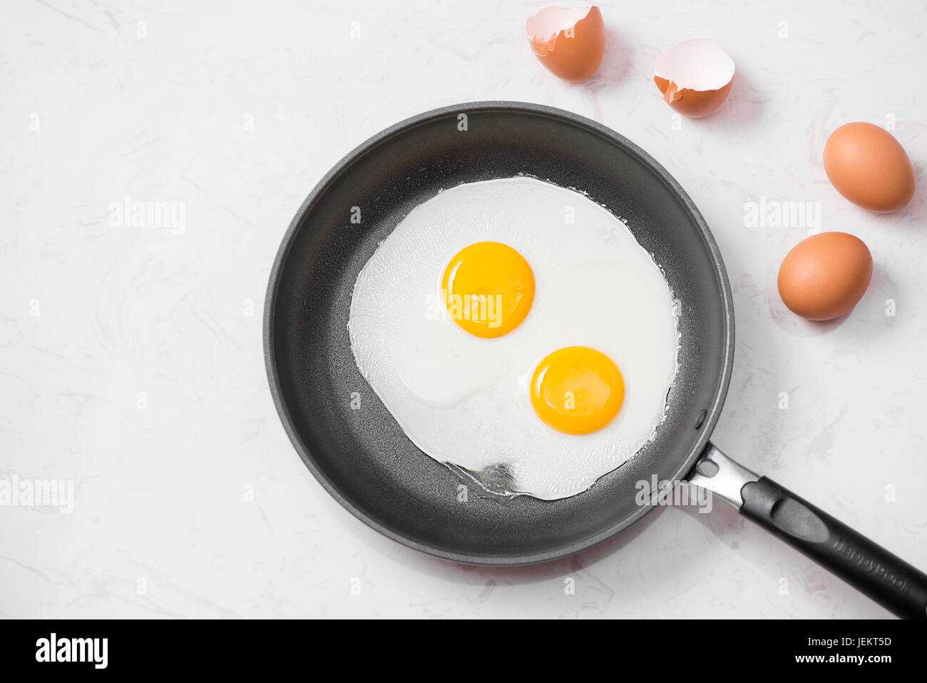 Top view of traditional healthy easy quick breakfast meal made of fried eggs served on a frying ...