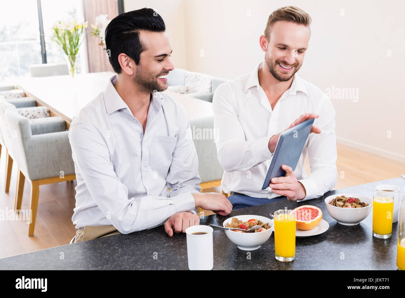 Smiling gay couple having breakfast Stock Photo - Alamy