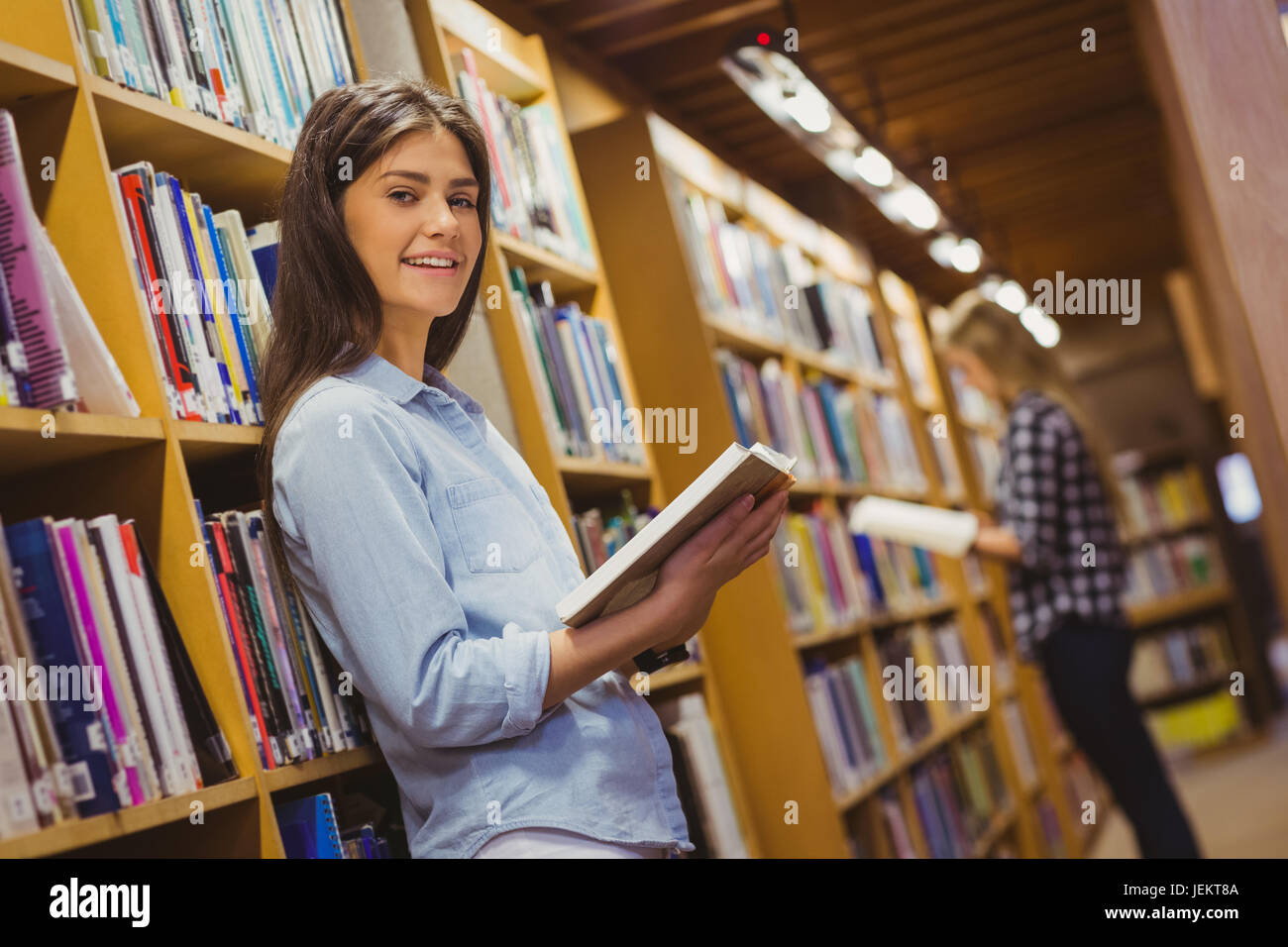 Serious students reading next to bookshelf Stock Photo - Alamy