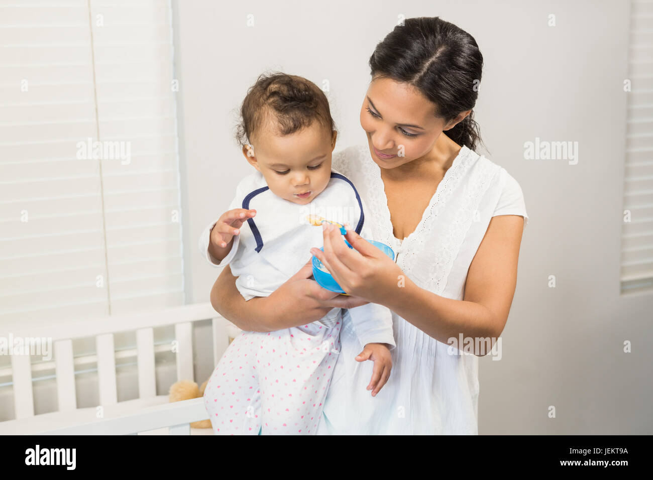 Smiling brunette feeding baby Stock Photo - Alamy