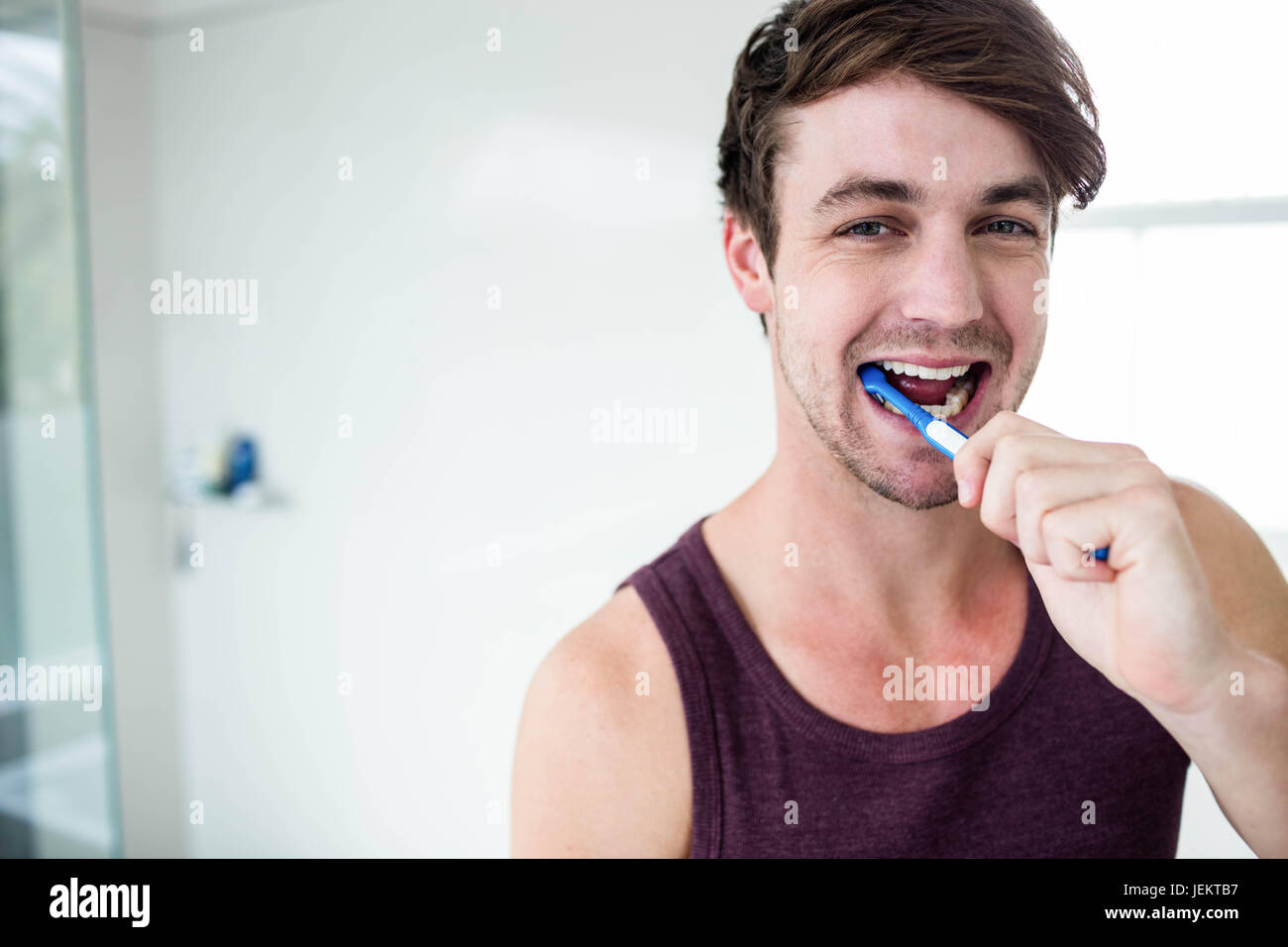 Handsome man cleaning his teeth Stock Photo - Alamy