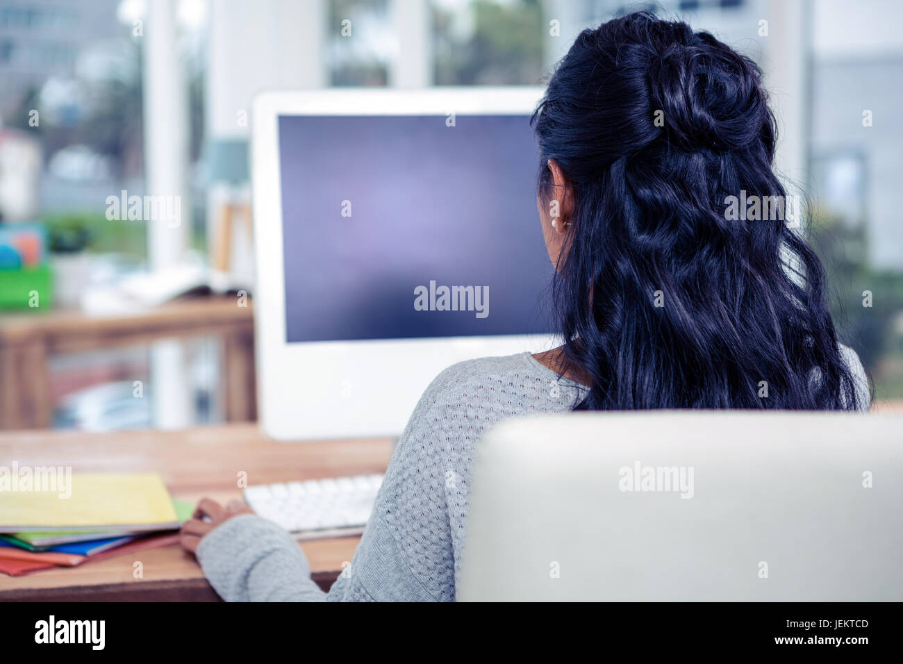 Rear view of woman using computer Stock Photo - Alamy