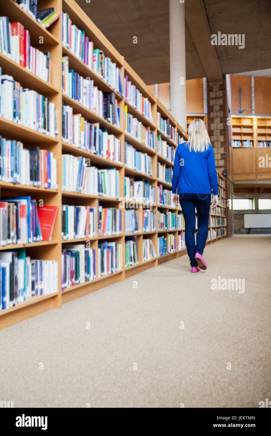 Female student walking in the library Stock Photo - Alamy