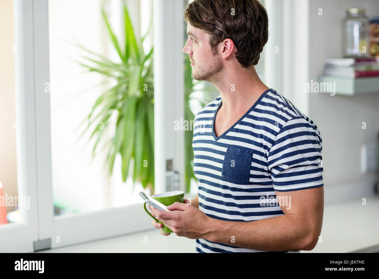 Handsome man looking out the window Stock Photo - Alamy