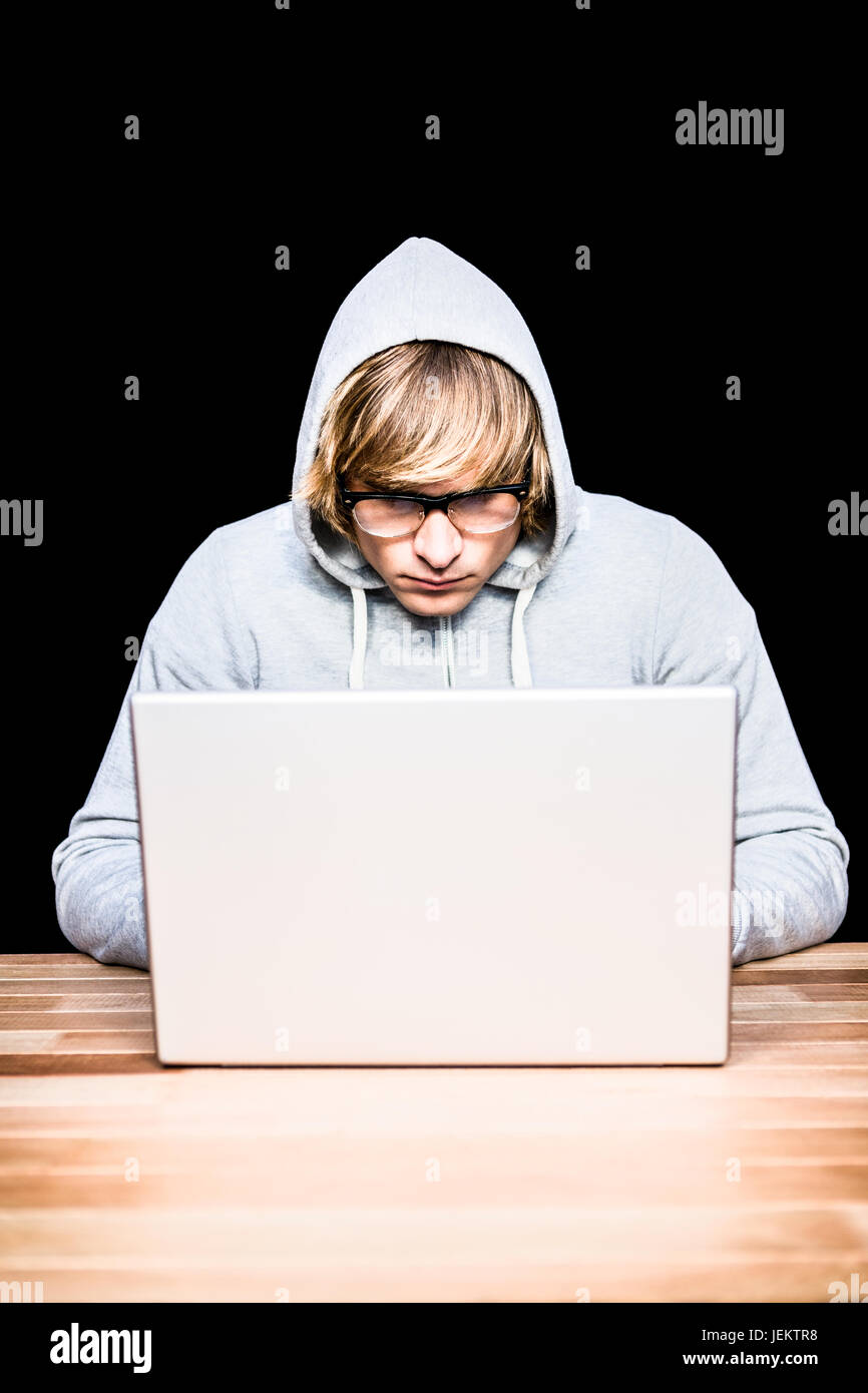Man in hood jacket hacking a laptop Stock Photo - Alamy