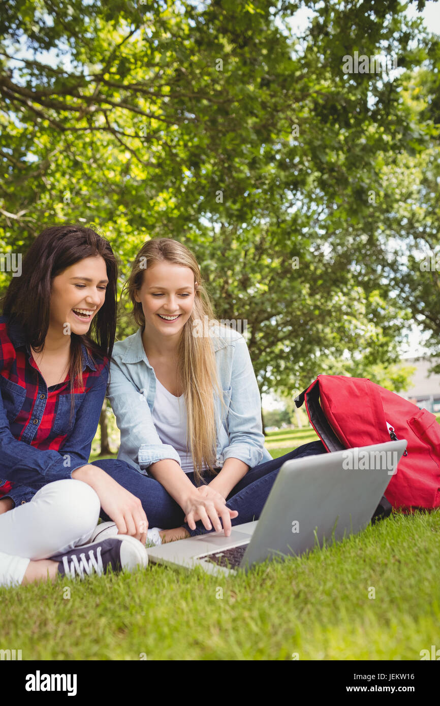 Smiling students using laptop Stock Photo - Alamy