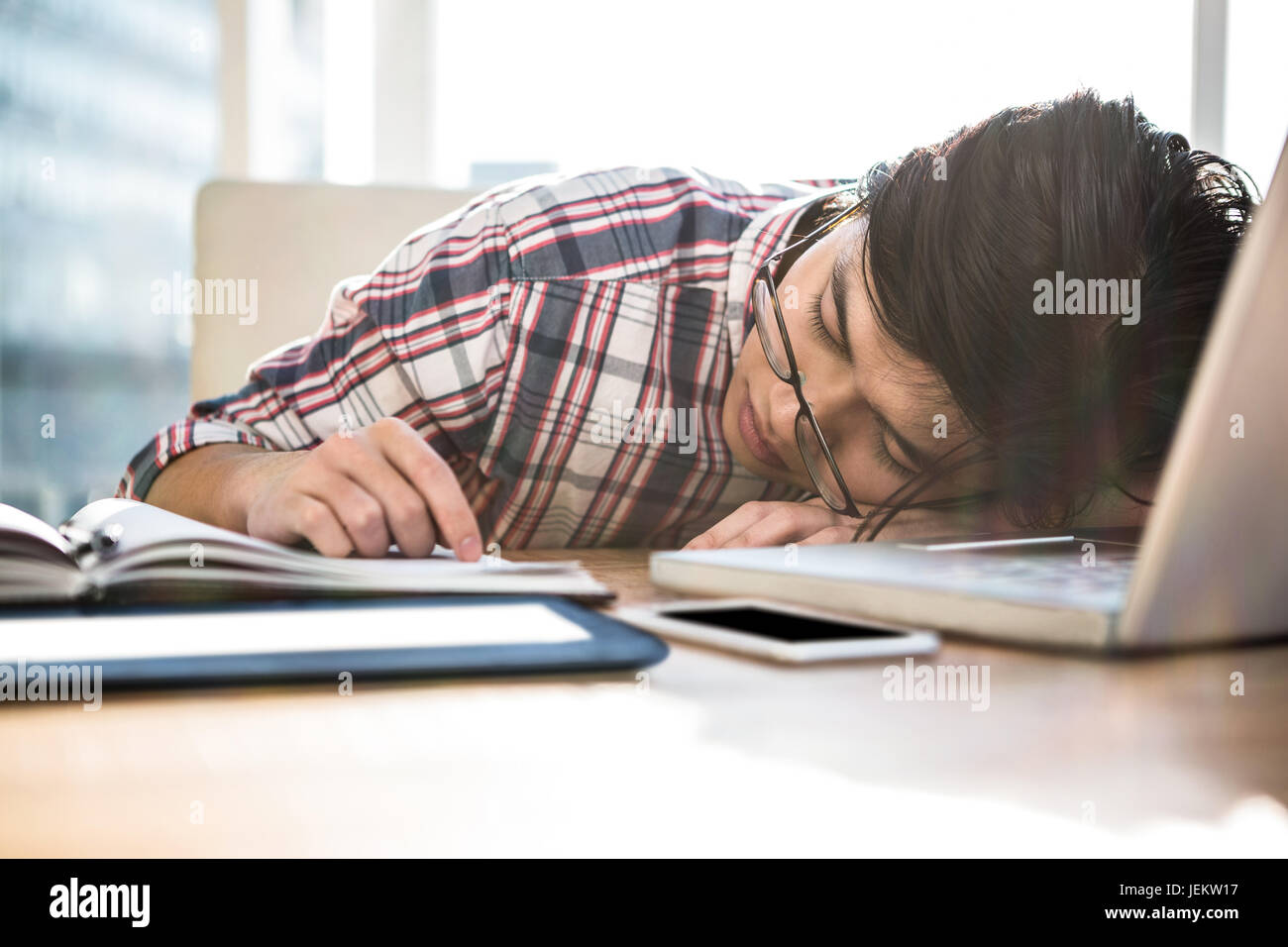 Hipster businessman falling asleep on desk Stock Photo - Alamy