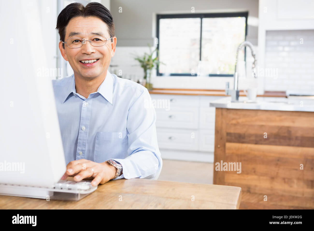 Smiling man using computer Stock Photo - Alamy