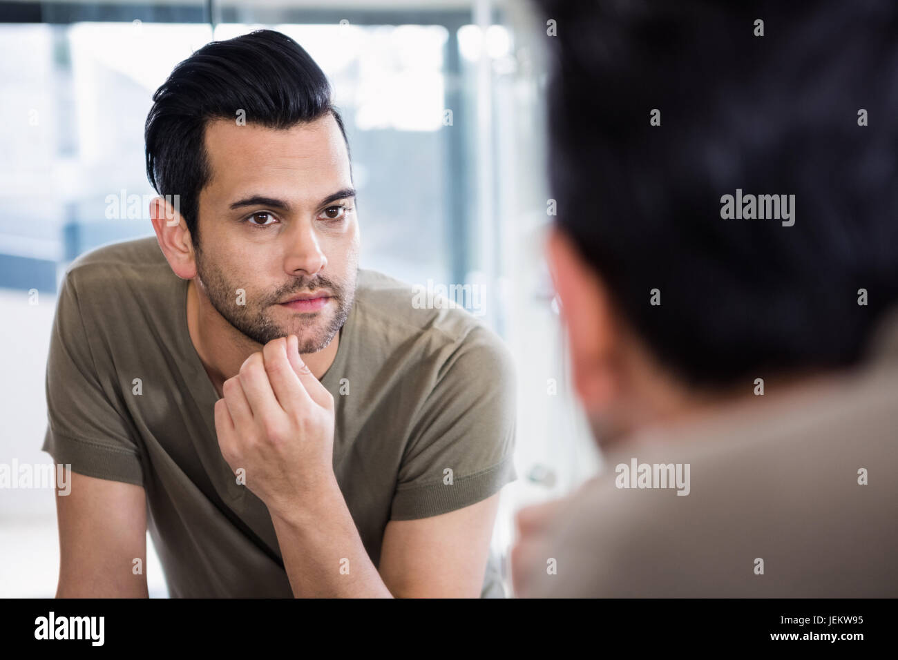 Handsome man looking in mirror Stock Photo - Alamy