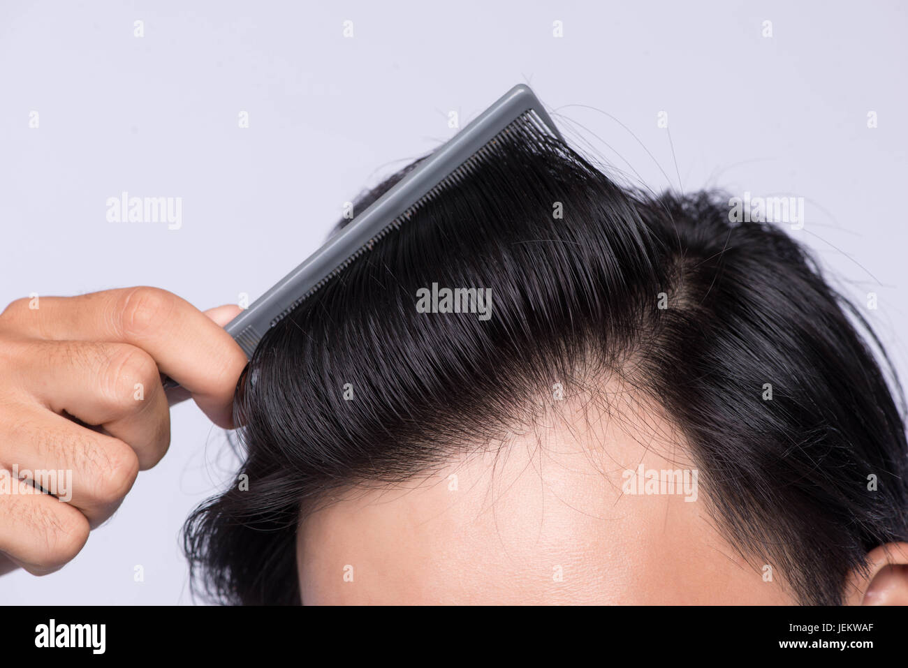 Close up photo of clean healthy man's hair. Young man comb his hair ...