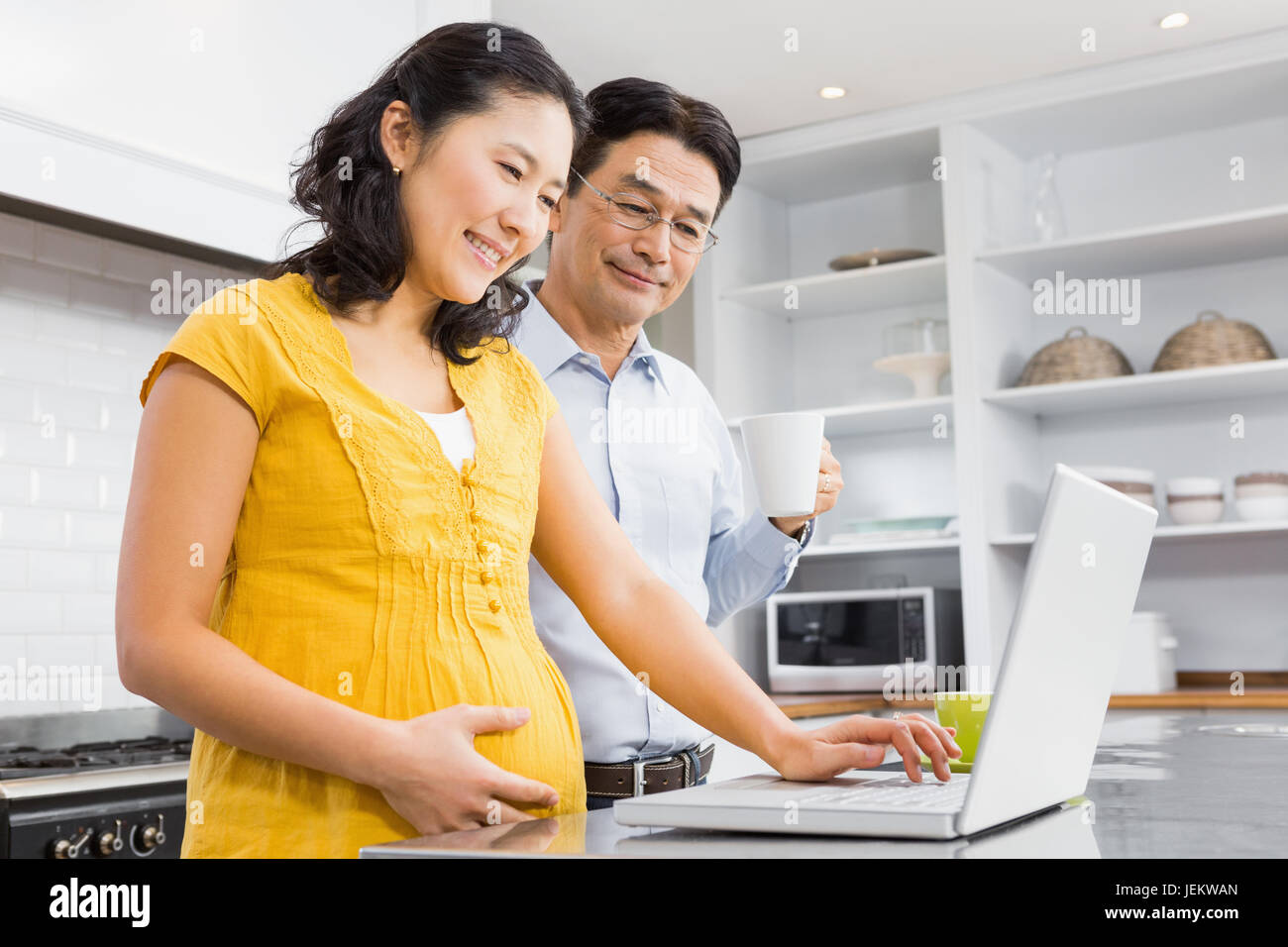 Happy expectant couple using laptop Stock Photo - Alamy
