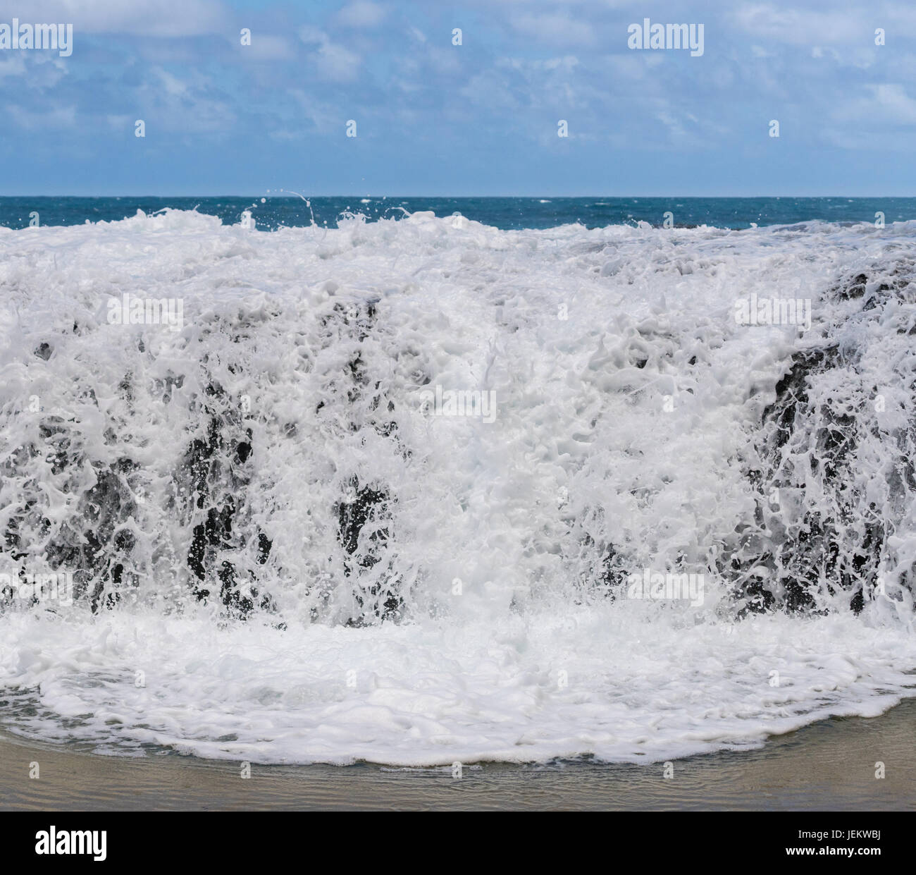 Frozen motion of ocean waterfall over rocks at Lumahai Beach Stock ...