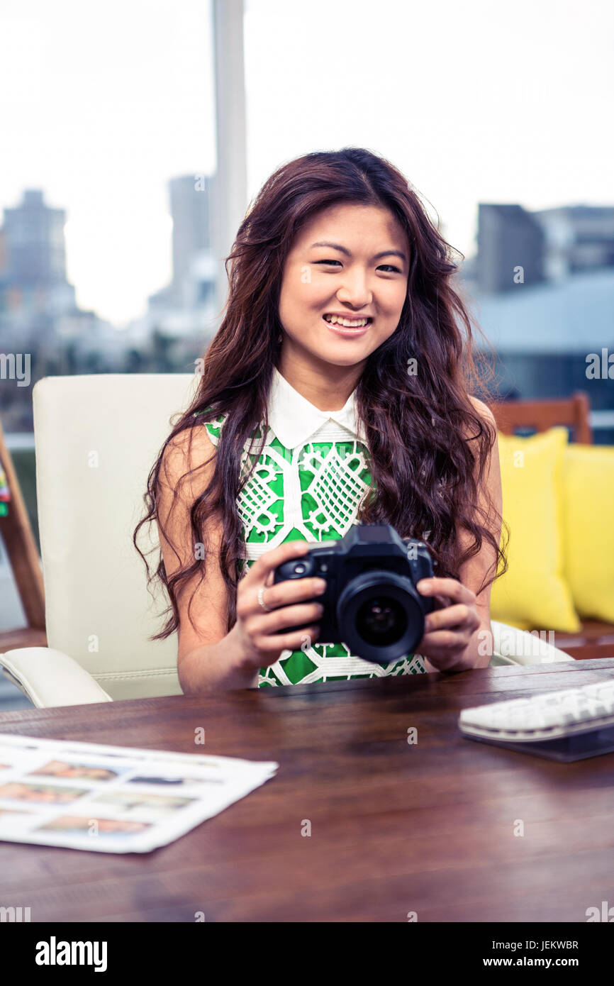 Creative businesswoman holding camera Stock Photo - Alamy