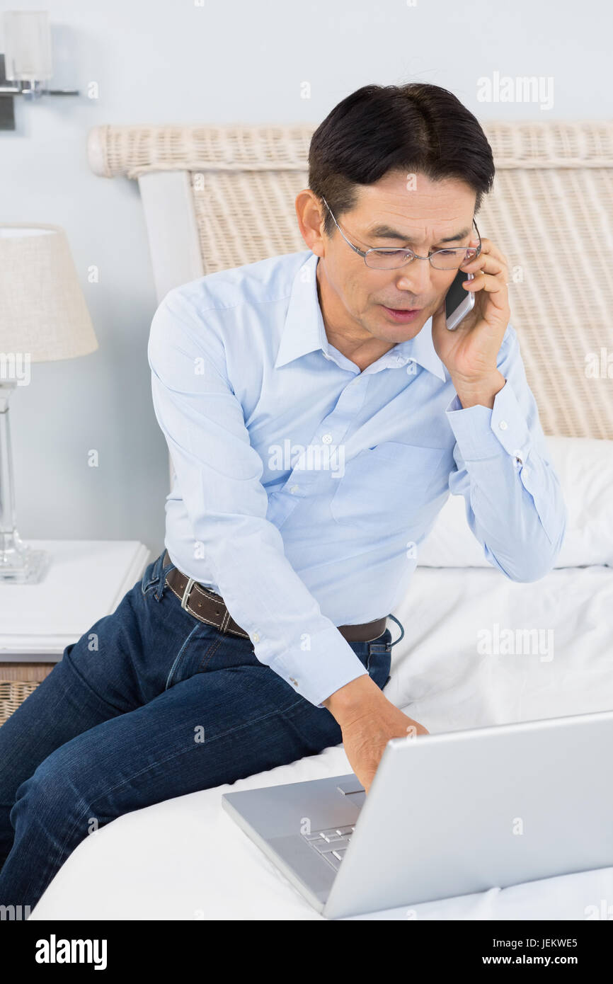 Man on a phone call using laptop Stock Photo - Alamy
