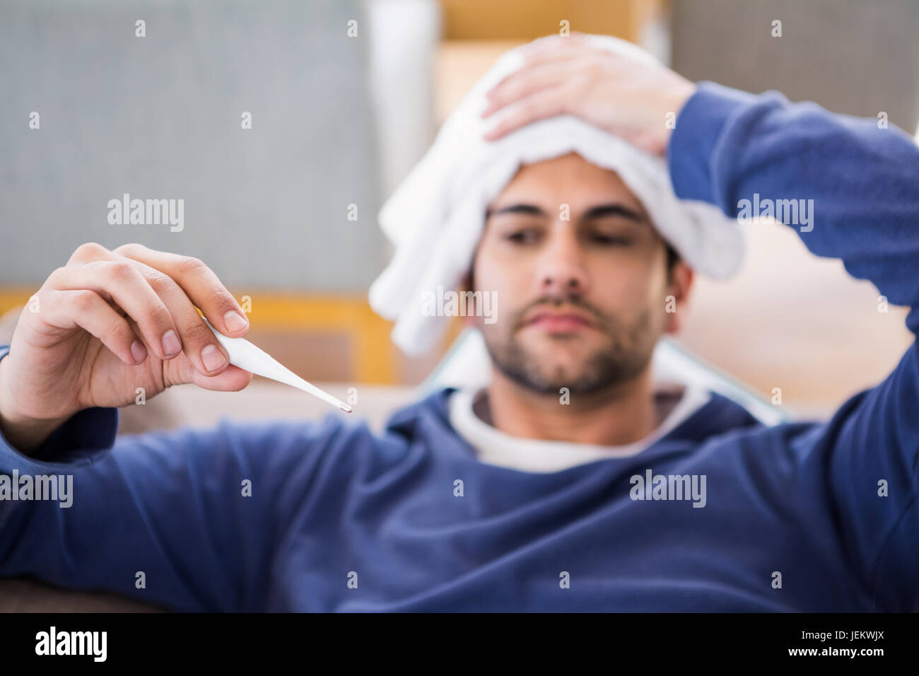 Sick man checking his temperature Stock Photo - Alamy