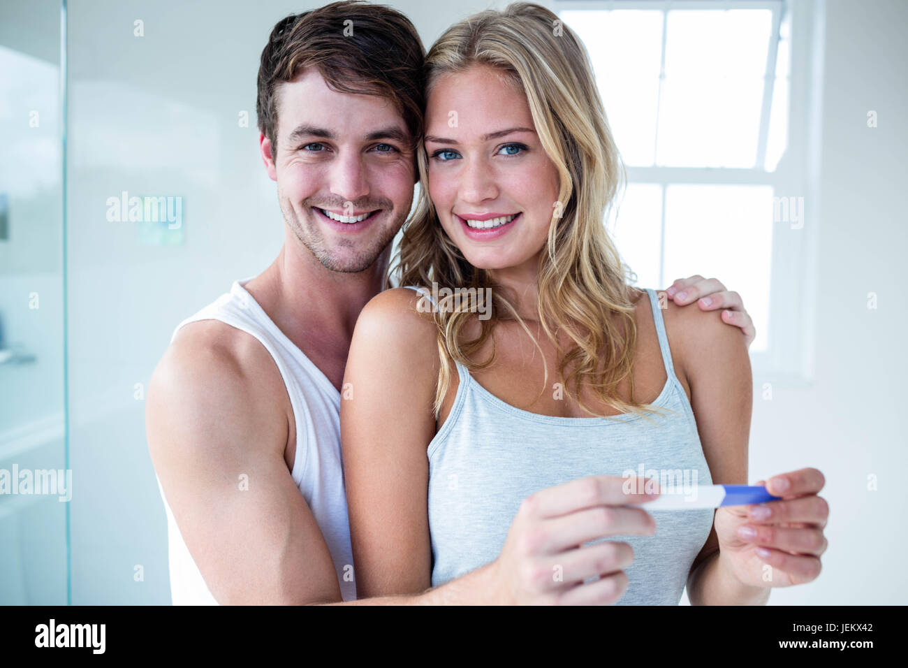 Happy couple looking at pregnancy test Stock Photo - Alamy