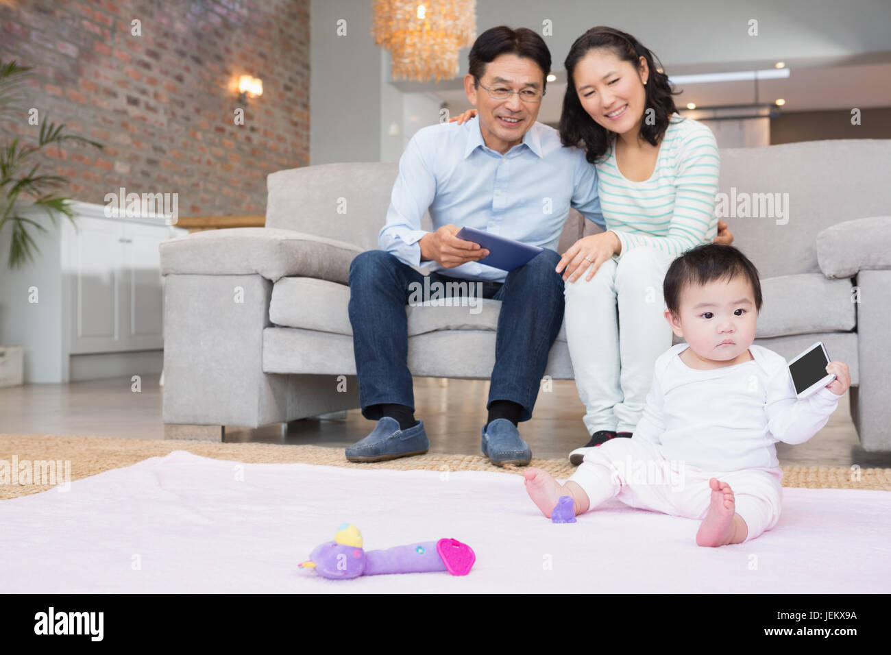 Happy parents looking at their baby daughter Stock Photo - Alamy