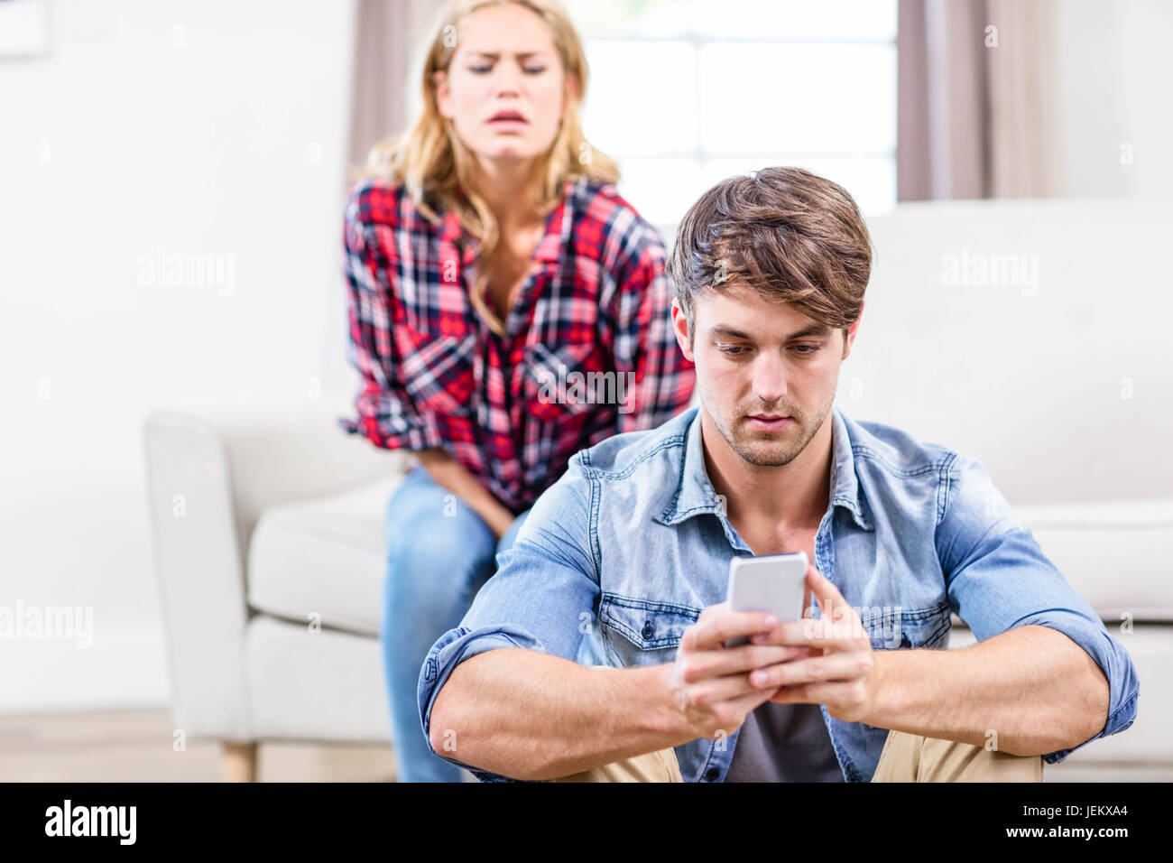 Girlfriend spying on boyfriend texting Stock Photo - Alamy