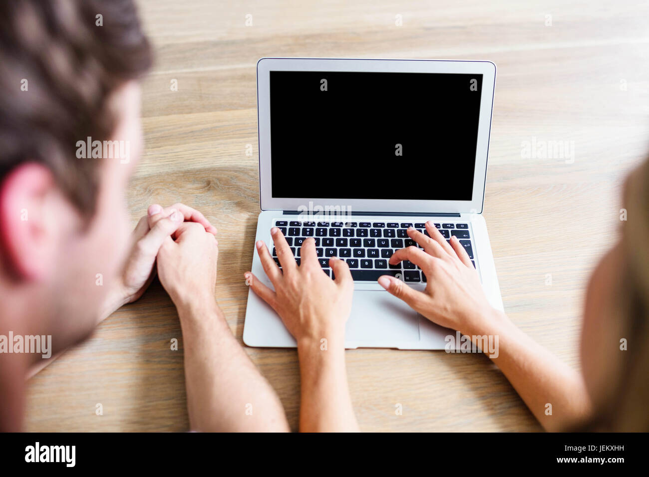 Focused couple using laptop Stock Photo - Alamy