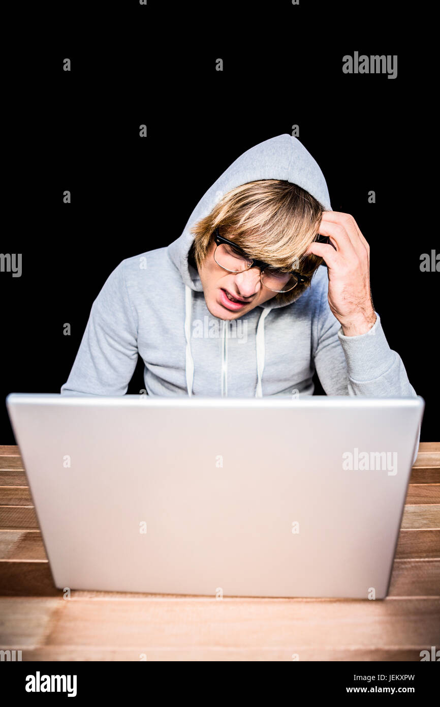 Man in hood jacket hacking a laptop Stock Photo - Alamy