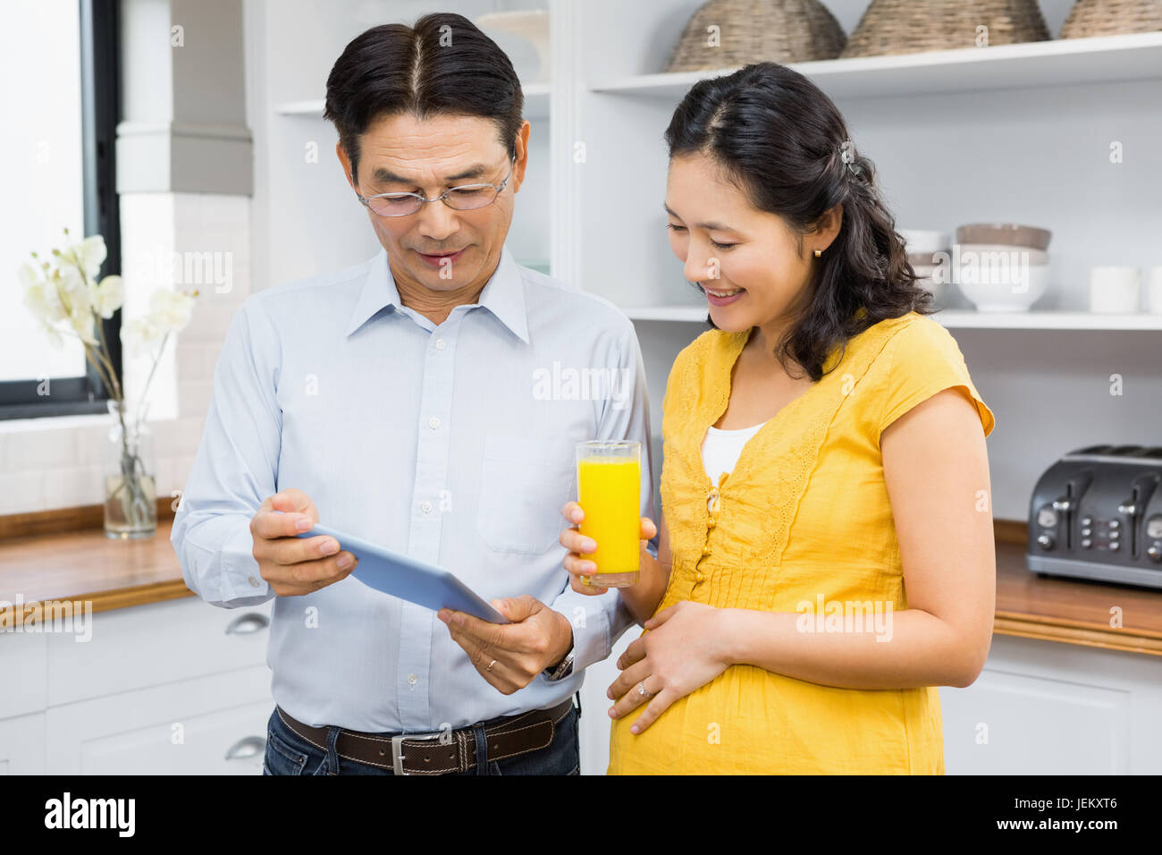 Happy pregnant couple tablet hi-res stock photography and images - Alamy