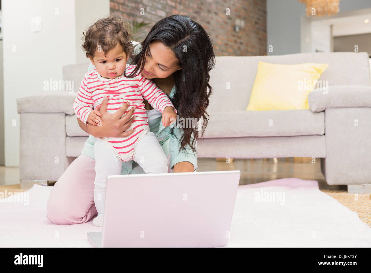 Happy mother with her baby using laptop Stock Photo - Alamy