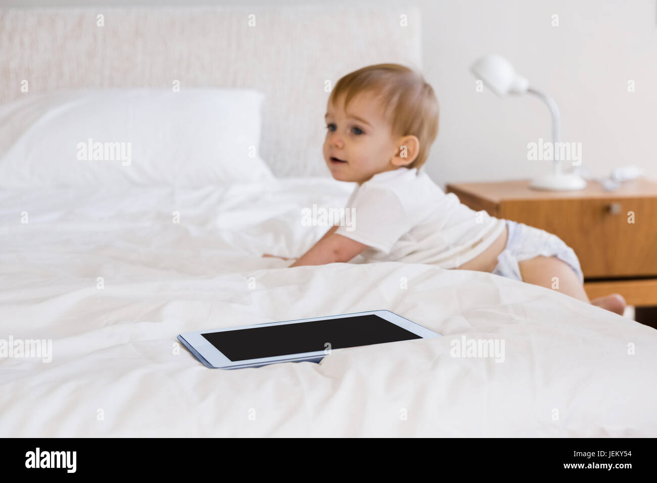 Cute baby climbing down the bed Stock Photo - Alamy