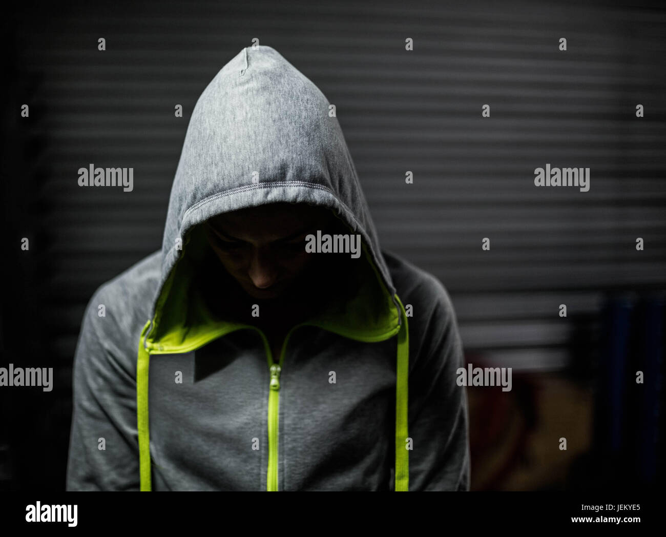 Athlete wearing hood with head down Stock Photo - Alamy