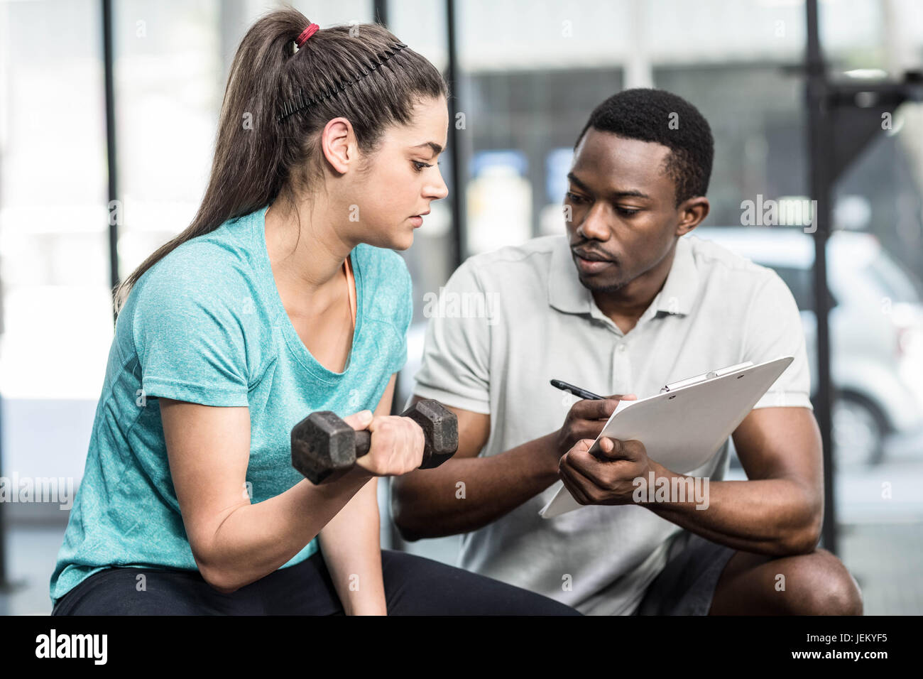 Trainer giving advice to woman Stock Photo - Alamy