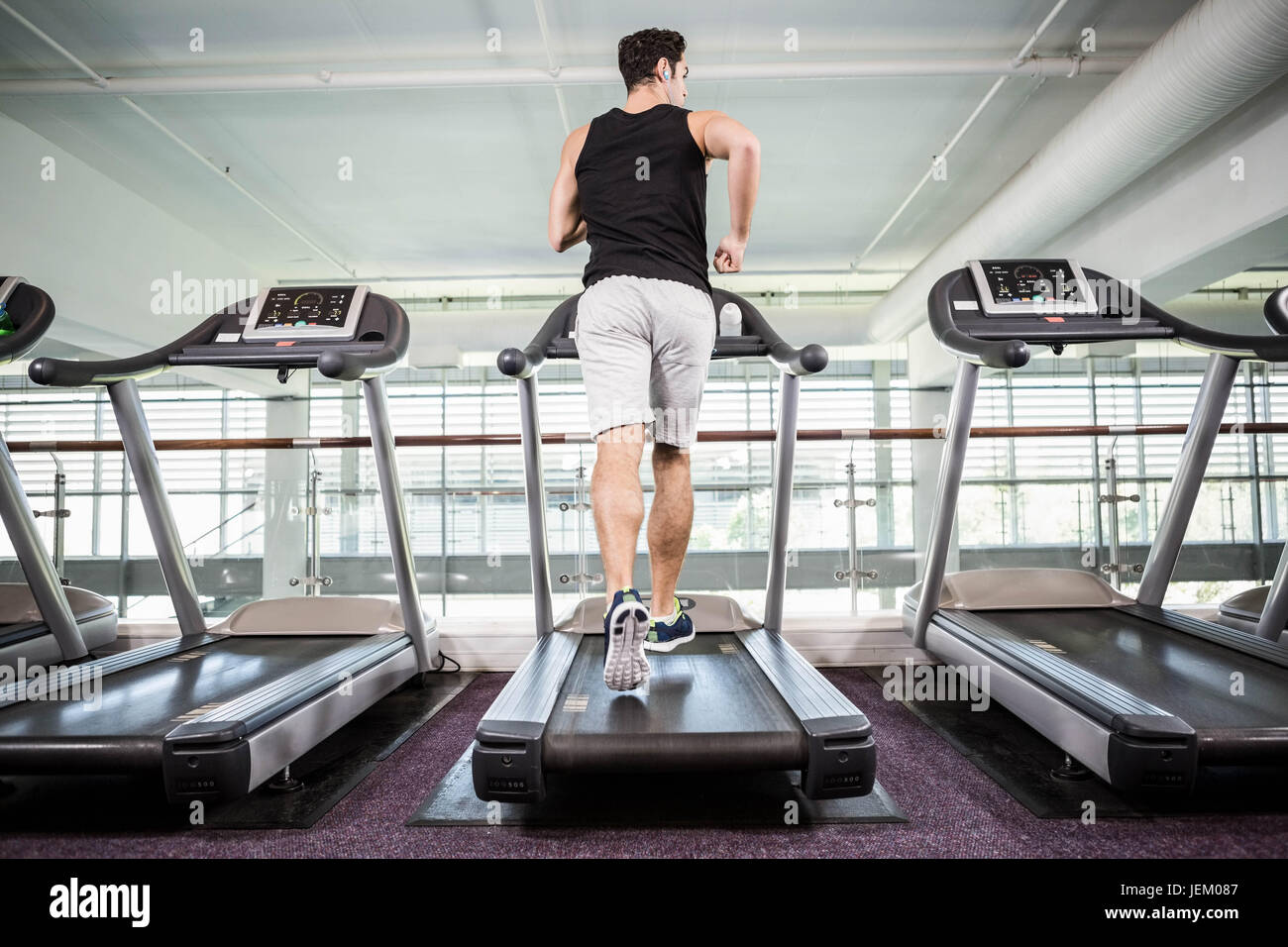 Fit man running on treadmill Stock Photo - Alamy