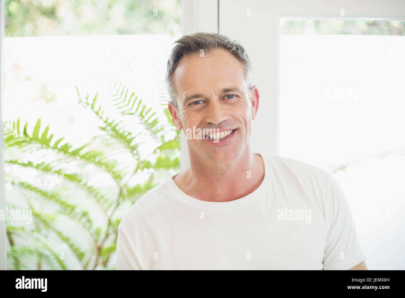 Handsome man smiling at camera Stock Photo - Alamy