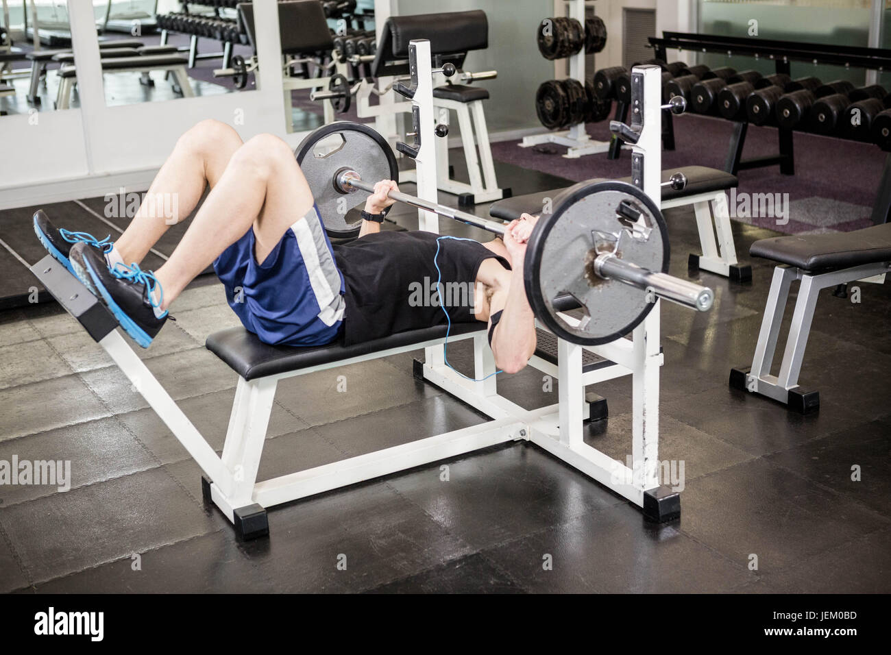 Muscular man lifting barbell on bench Stock Photo - Alamy
