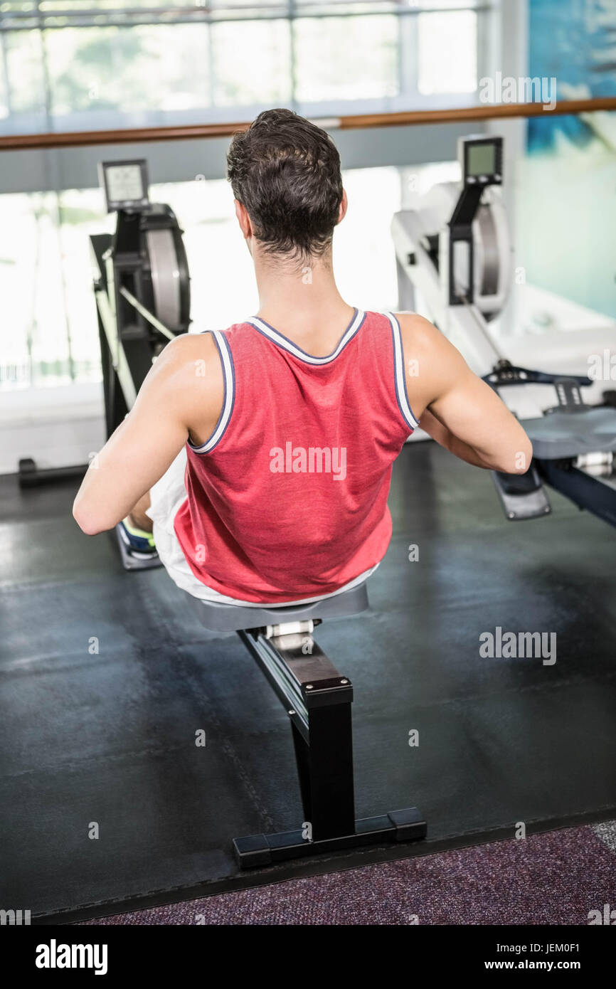 Muscular man on rowing machine Stock Photo - Alamy
