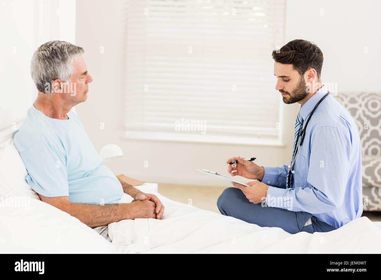 Handsome nurse visiting a mature man Stock Photo - Alamy