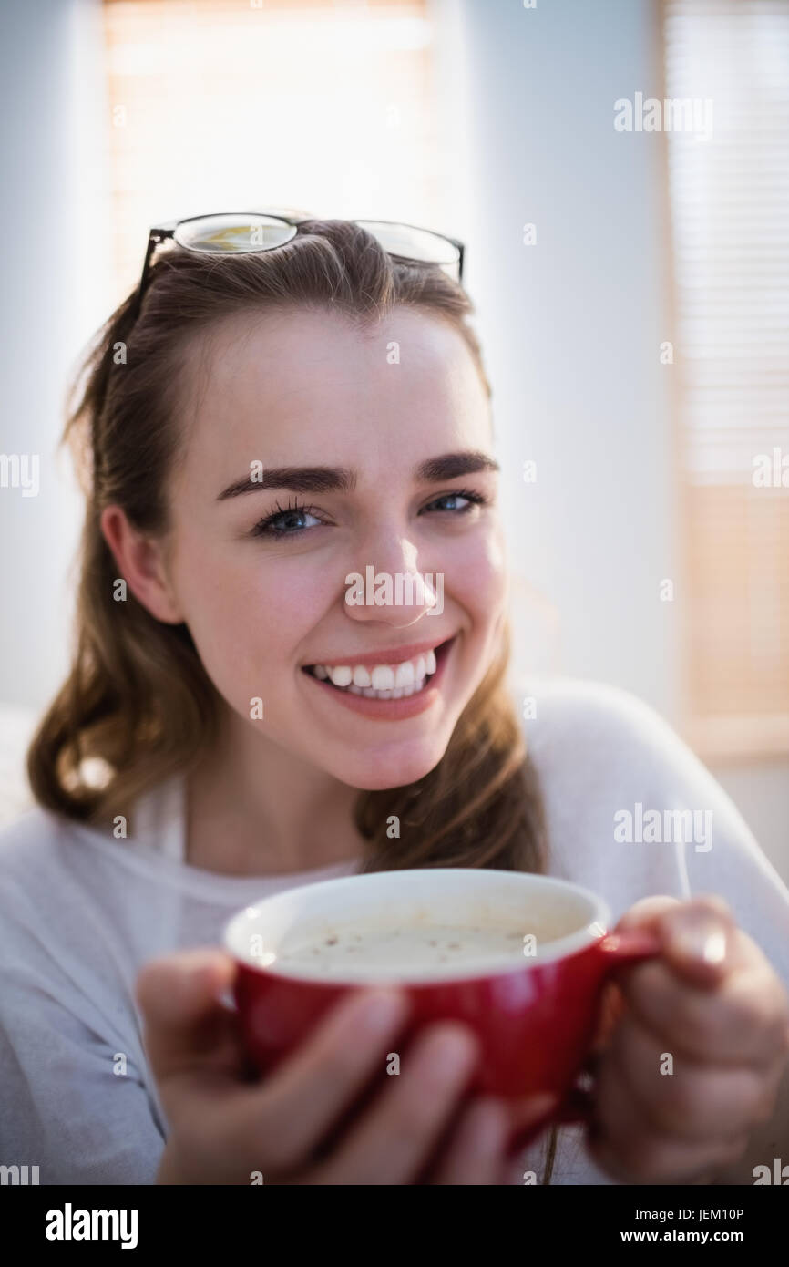 Pretty woman relaxing on couch with coffee Stock Photo - Alamy