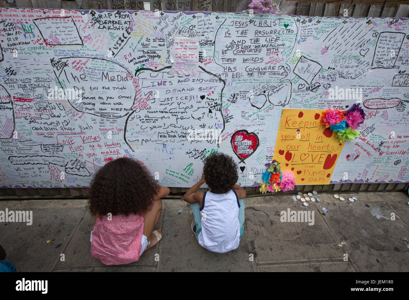 People leave tributes on a wall off condolence to the victims who died ...