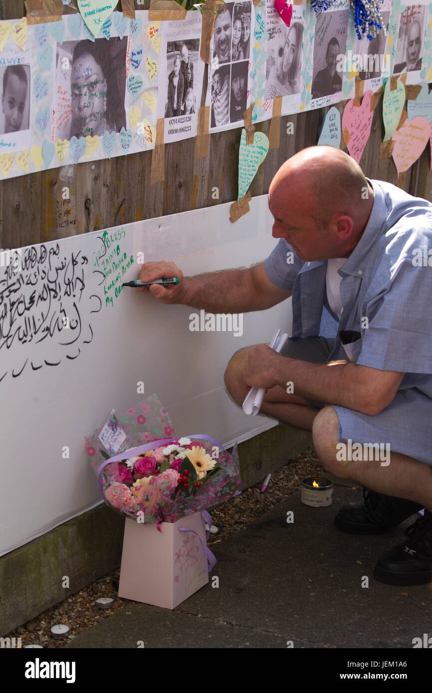 People leave tributes on a wall off condolence to the victims who died ...