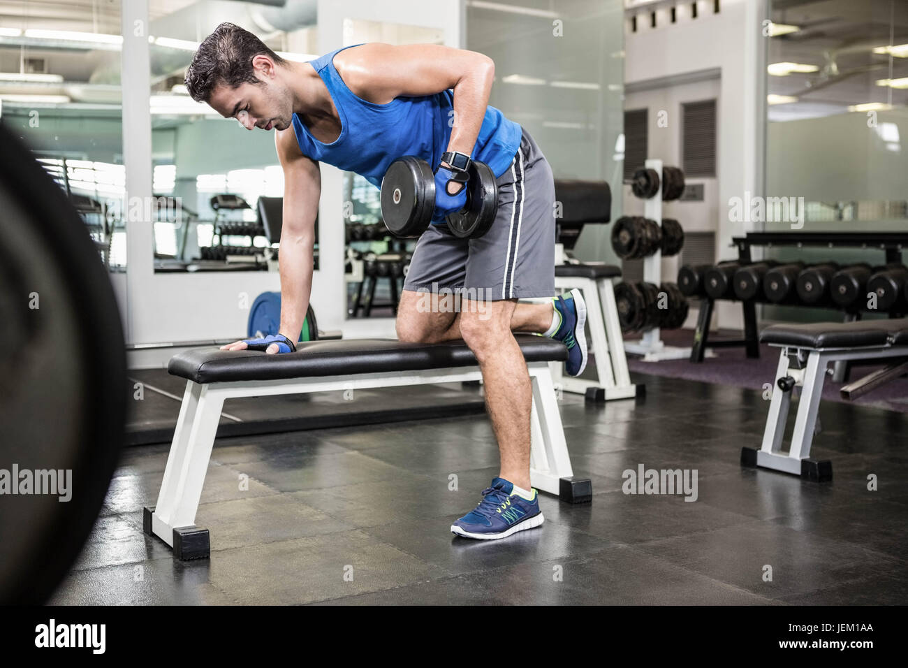 Handsome man lifting dumbbells on bench Stock Photo - Alamy