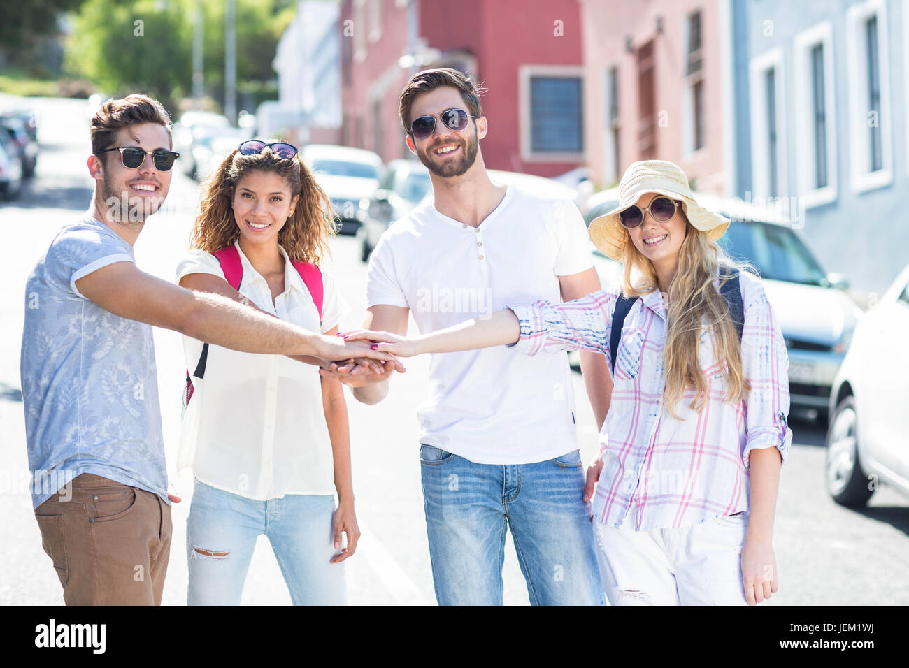 Hip friends putting hands together Stock Photo - Alamy