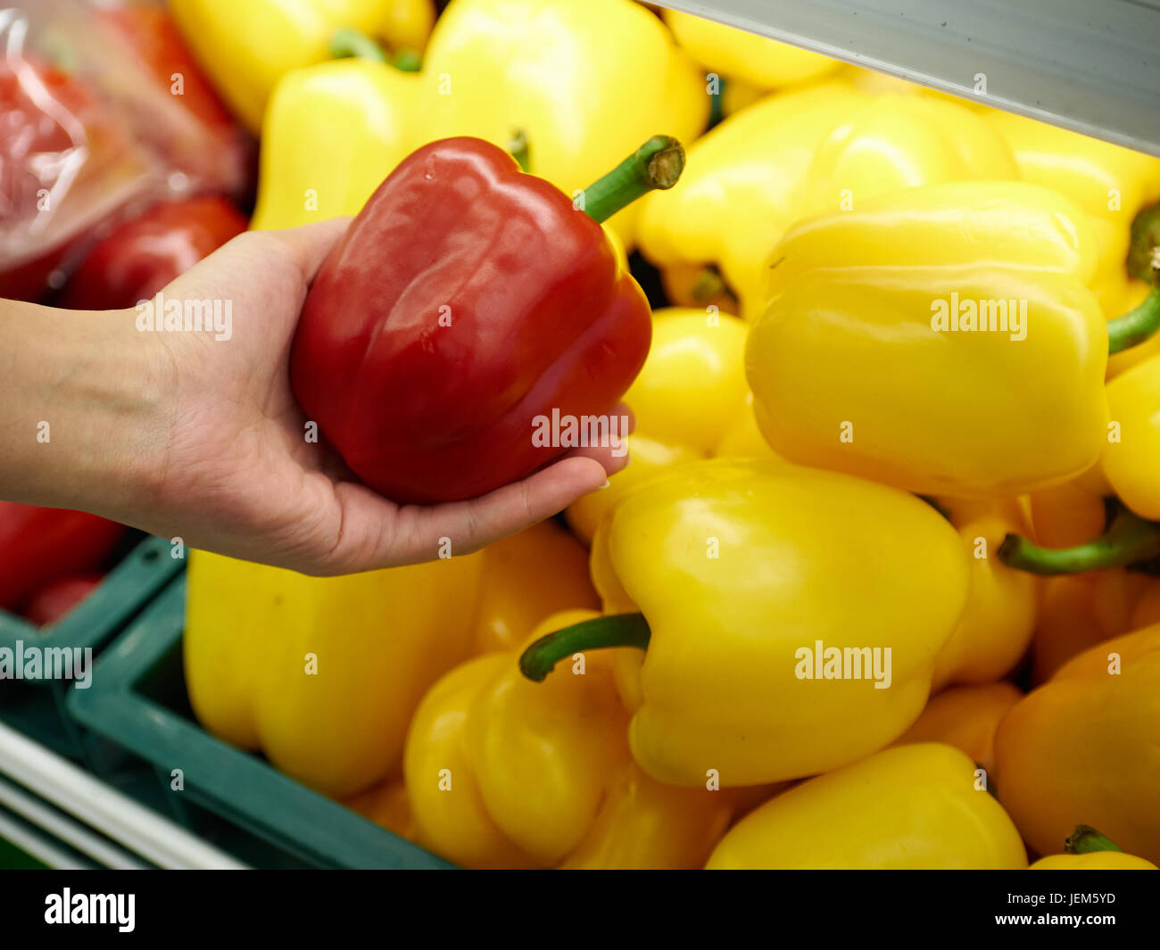 Woman choosing red sweet pepper in store Stock Photo - Alamy