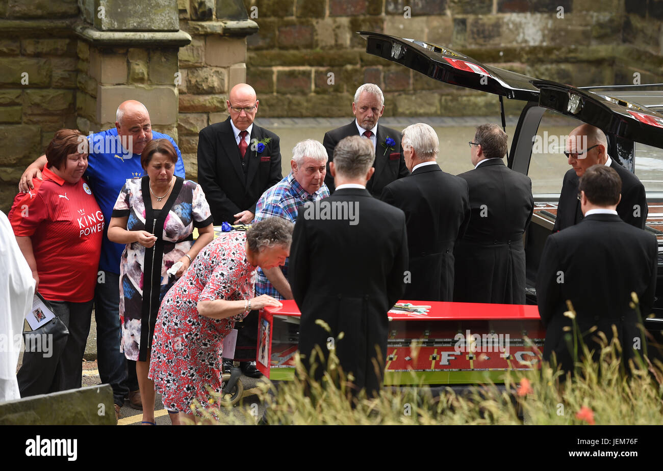 Sally Stokes (second from left) looks on as the coffins of her sons ...